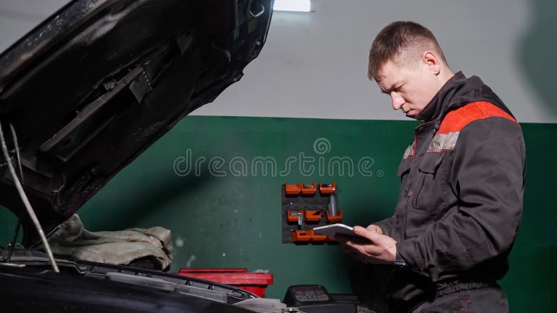 Worker Uses Digital Device To Check Automobile at Station Stock Photo ...
