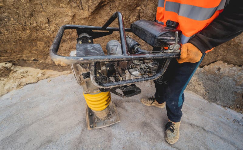 Worker Uses a Portable Vibration Rammer at Construction of a Power ...