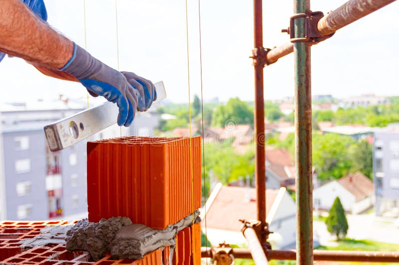 Worker Uses a Spirit Level To Control Wall Made of Red Blocks Stock ...