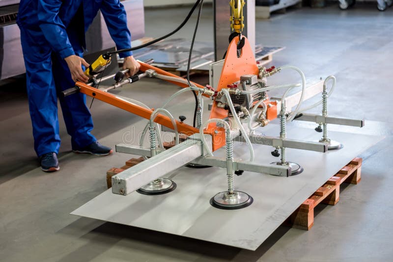 Worker Uses Suction Cups for Transporting Large Sheets of Metal Stock ...