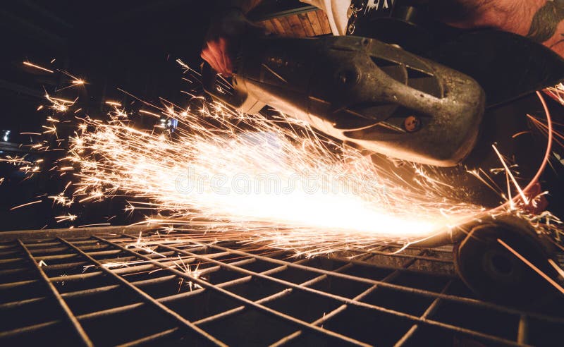 Worker Using Angle Grinder in Factory and Throwing Sparks. Stock Photo ...
