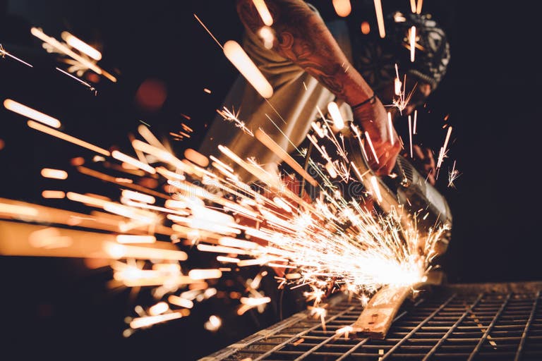 Worker Using Angle Grinder in Factory and Throwing Sparks. Stock Photo ...