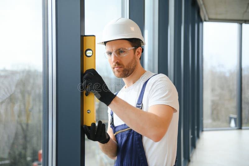 Worker Using Bubble Level after Plastic Window Installation Indoors ...