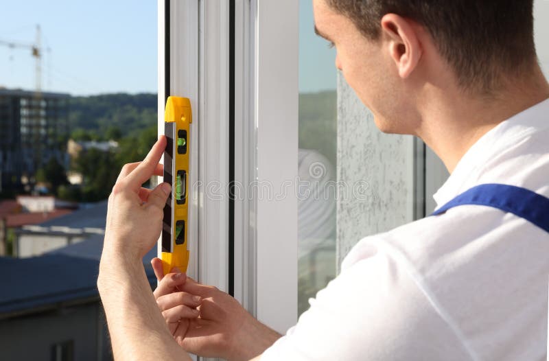 Worker Using Bubble Level after Plastic Window Installation Indoors ...