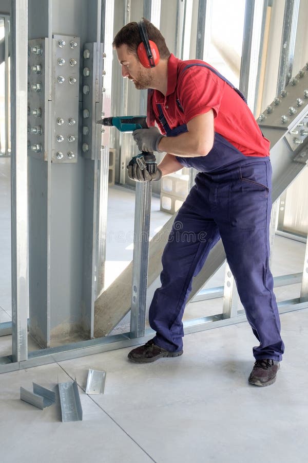 Worker Using a Drill in a Construction Site Stock Photo - Image of ...