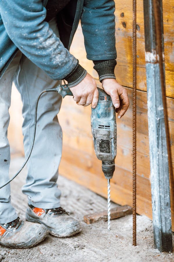 Worker Using a Rotary Power Tool on Construction Site and Creating ...