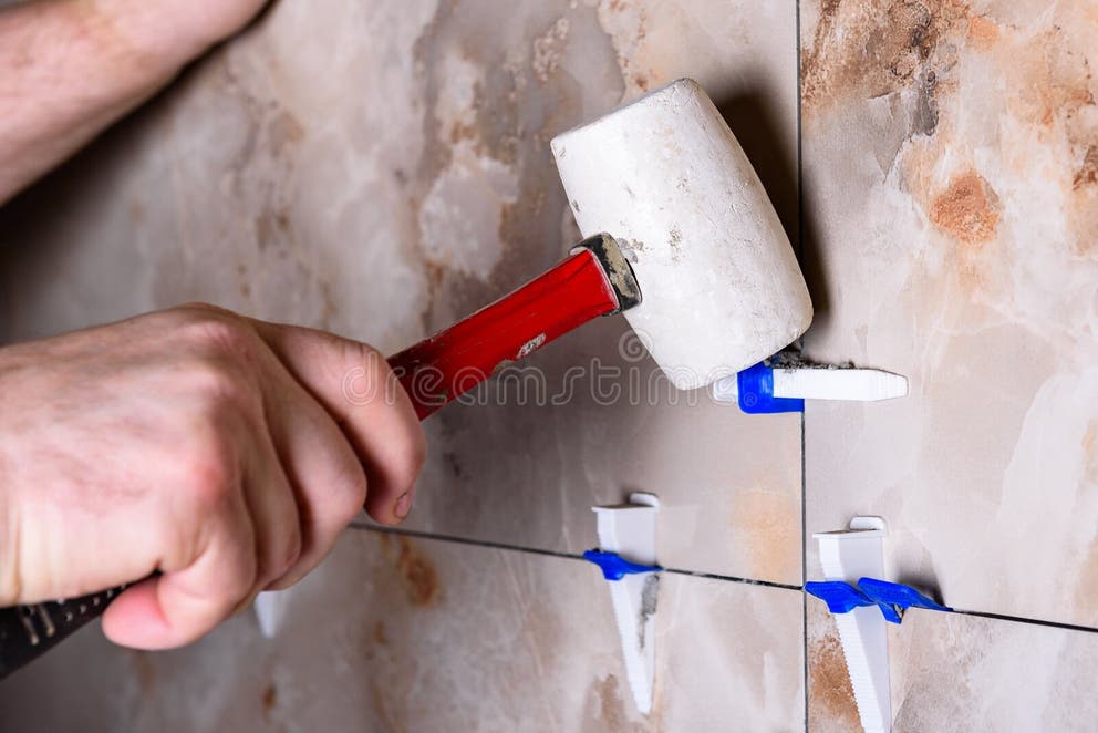 Worker Using Hammer for Removing Tile Leveling System with Plastic ...