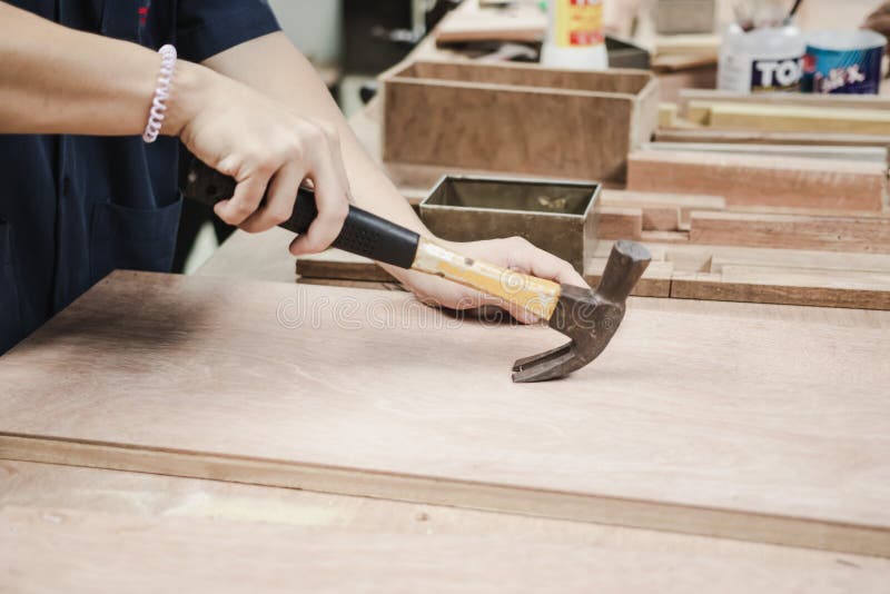 Worker Using Hammer To Remove Nail from Piece of Wood Stock Photo ...