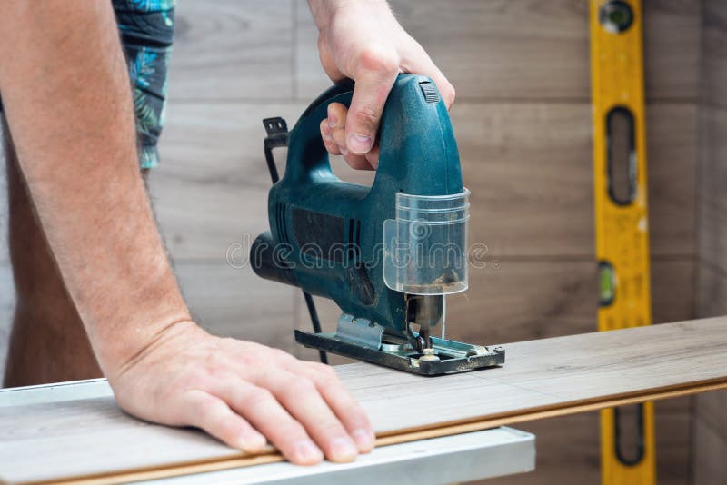 A Worker Using a Jigsaw Saws Laminate Boards Stock Photo - Image of ...