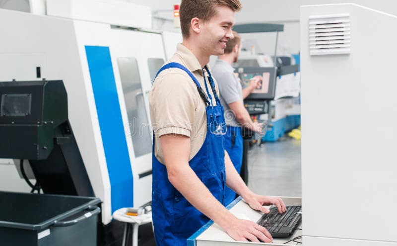 Worker Using Keyboard To Enter Data into a Machine on Factory Floor ...