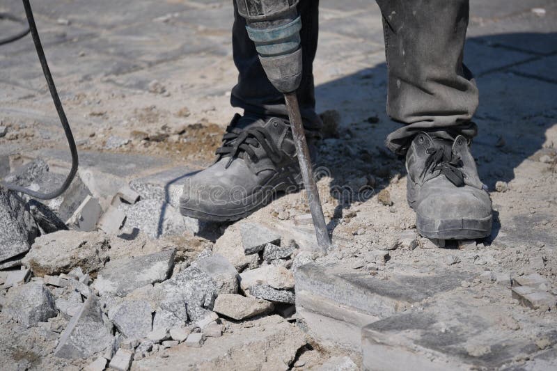 Worker Using Pneumatic Tool To Break Concrete at Construction Site ...
