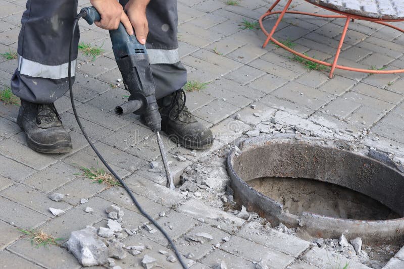 Worker Using Power Drill on Pavement Near Round Hole, Breaking Concrete ...