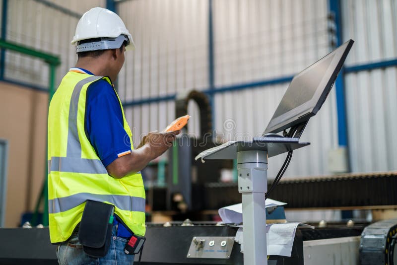A Worker is Using Remote Control To Control Steel Laser Cutting Machine ...