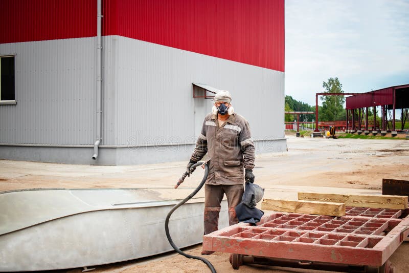 Worker Using Sandblasting Equipment To Clean Rust from a Metal ...