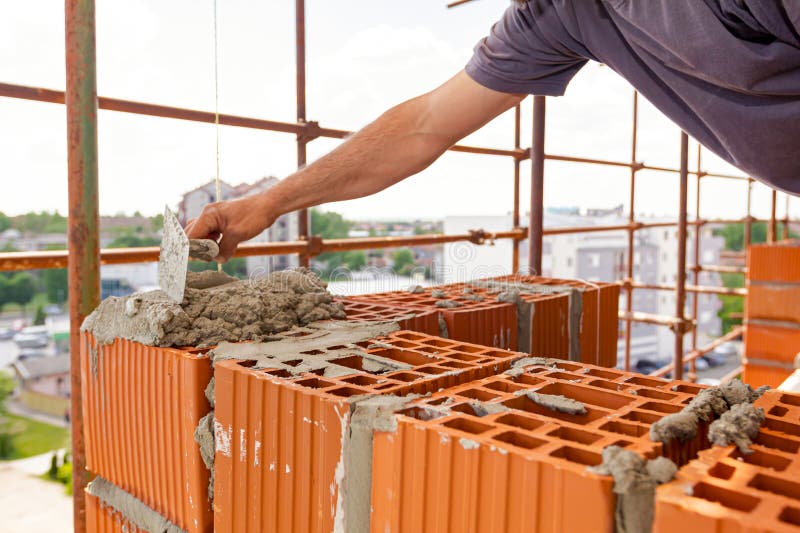 Builder Using Spatula To Set Up Mortar Over Red Brick, Building Site ...