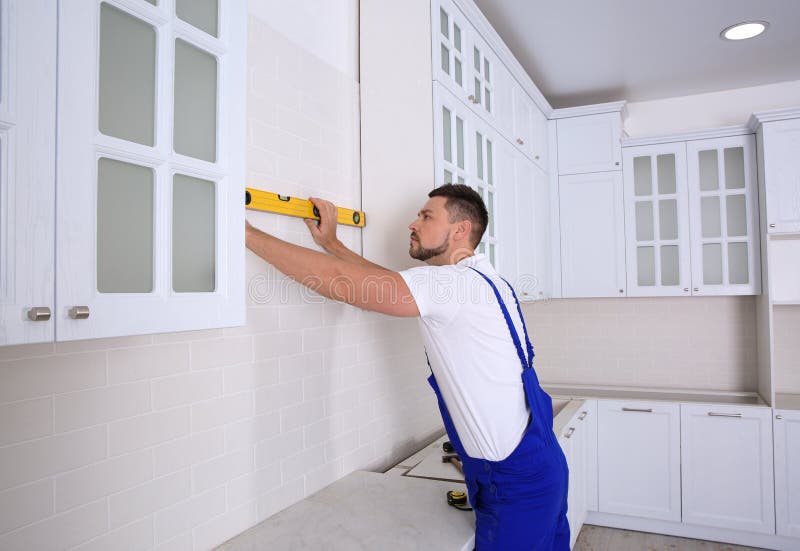 Worker Using Spirit Level while Installing Furniture in Kitchen Stock ...