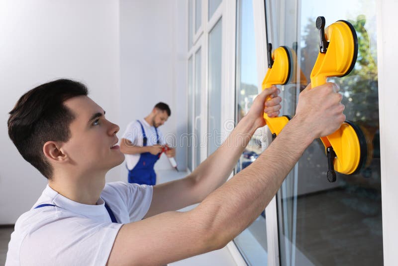 Worker Using Suction Lifters during Plastic Window Installation Indoors ...