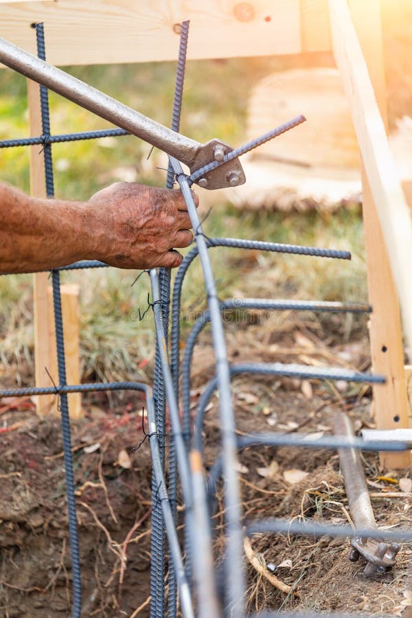 Hands of Worker Using Tools To Bend Steel Rebar at Construction Site ...