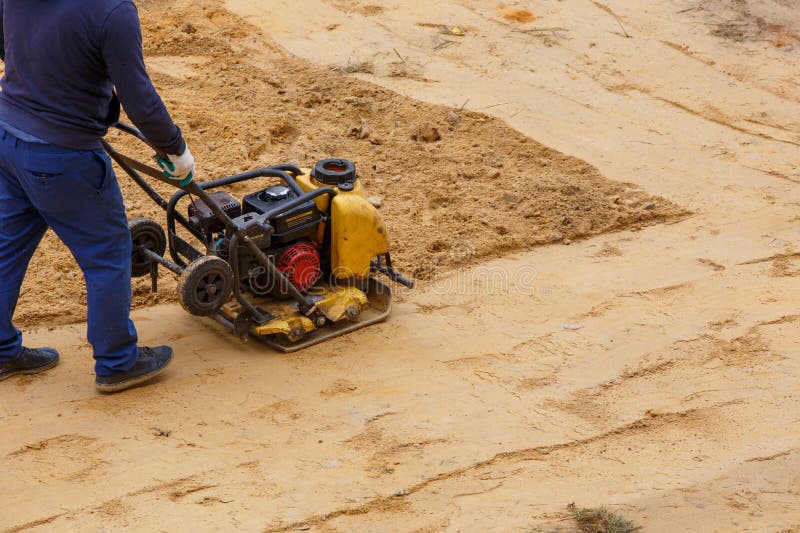 Worker in Use Vibratory Plate Compactor for Path Construction. Plate ...