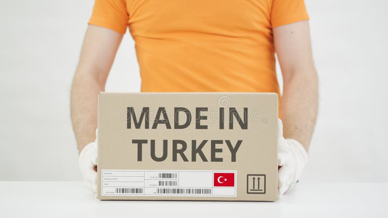 Worker Wearing Orange Uniform Puts Box with MADE in TURKEY Print on the ...