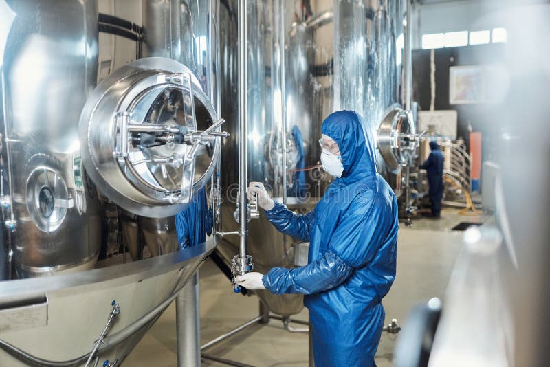 Worker in Protective Gear Operating Equipment at Factory Stock Photo ...
