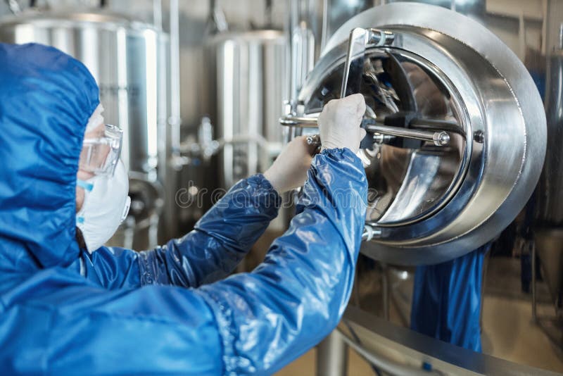 Worker in Protective Gear Operating Equipment at Factory Stock Photo ...
