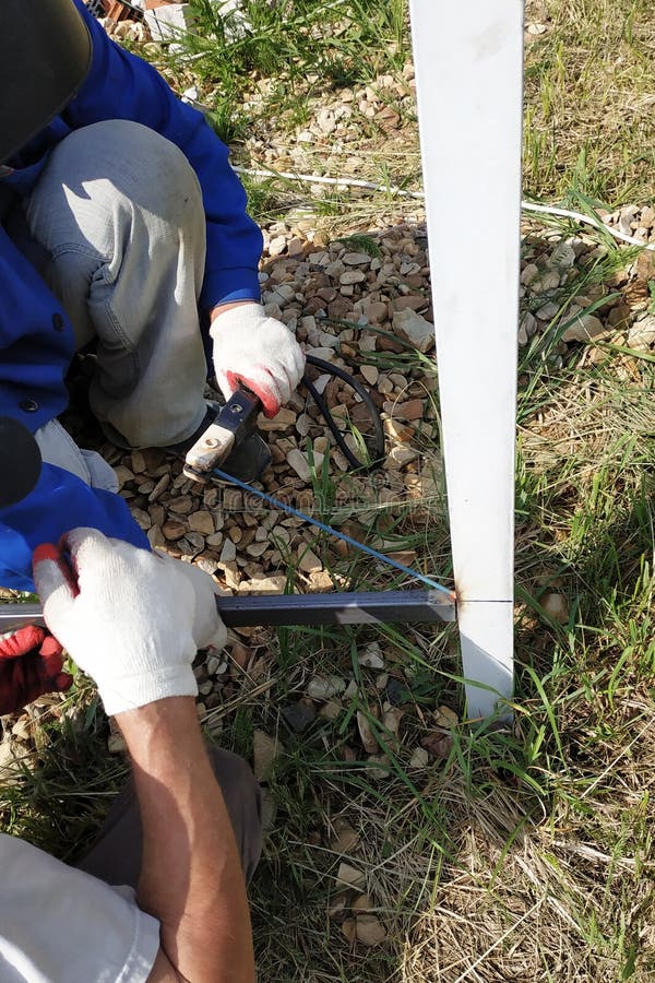 Worker with Welding Machine Welds the Fence Around the House. Stock ...
