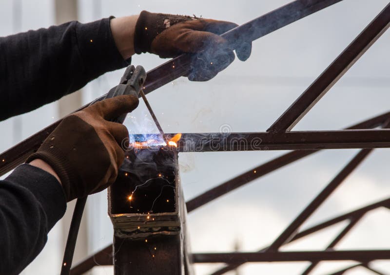 A Worker Welds Metal at a Construction Site. Stock Photo - Image of ...