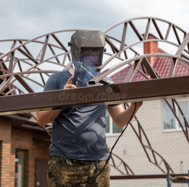 A Worker Welds Metal at a Construction Site. Stock Image - Image of ...