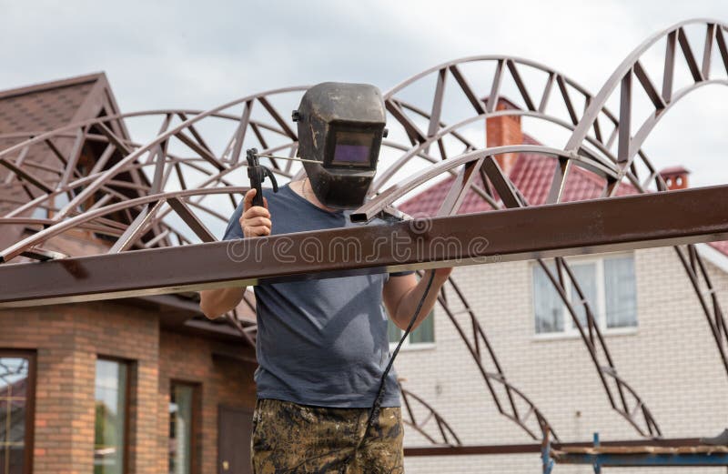 A Worker Welds Metal at a Construction Site. Stock Photo - Image of ...