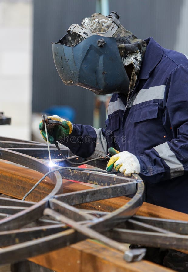 A Worker Welds Metal at a Construction Site. Stock Image - Image of ...