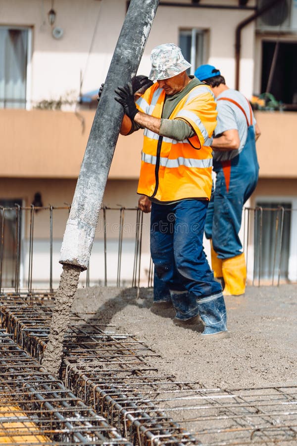 Worker Working on Building a House and Pouring Cement into Beams Stock ...