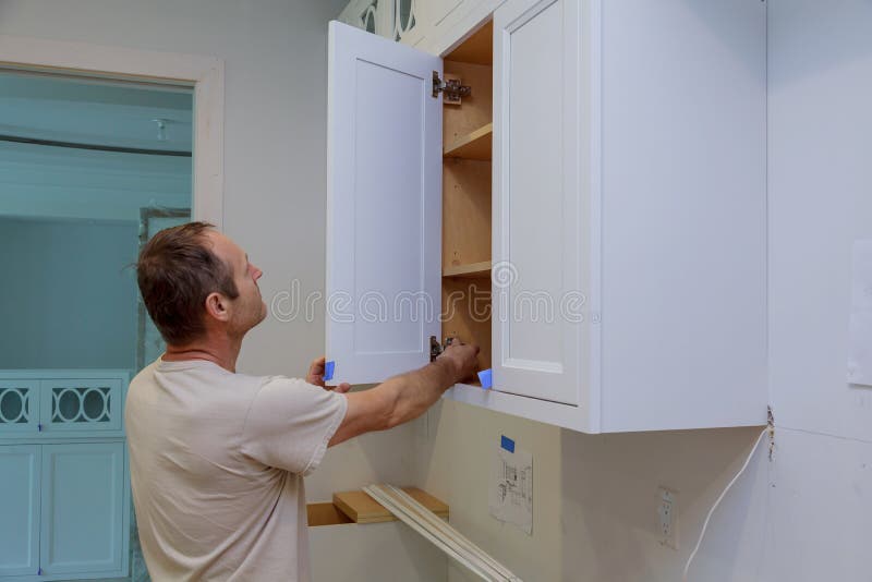 Worker Working on the Door of a New Kitchen Cabinet in a New House ...