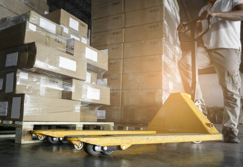 Worker Working with Hand Pallet Jack Unloading Cargo Boxes at the ...