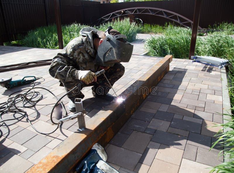 A Worker Works with Metal Welding at a Construction Site. Stock Image ...