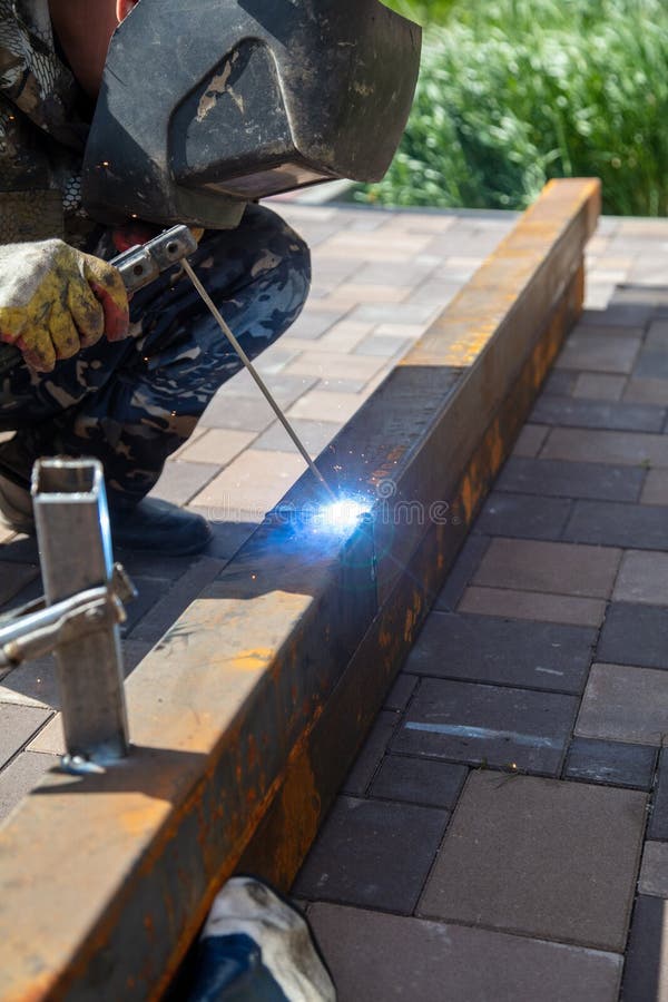 A Worker Works with Metal Welding at a Construction Site. Stock Photo ...