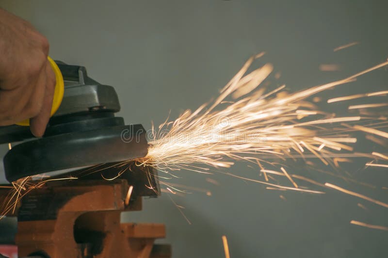 Worker in a Workshop Grinder Processes Metal, from Which Hot Bright ...