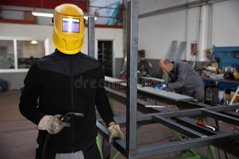 Worker in the Workshop with Welding Machine in Hand Ready To Work Stock ...