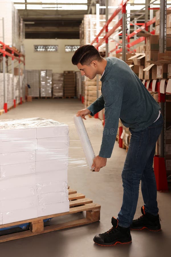 Worker Wrapping Boxes in Stretch Film at Warehouse Stock Photo - Image ...