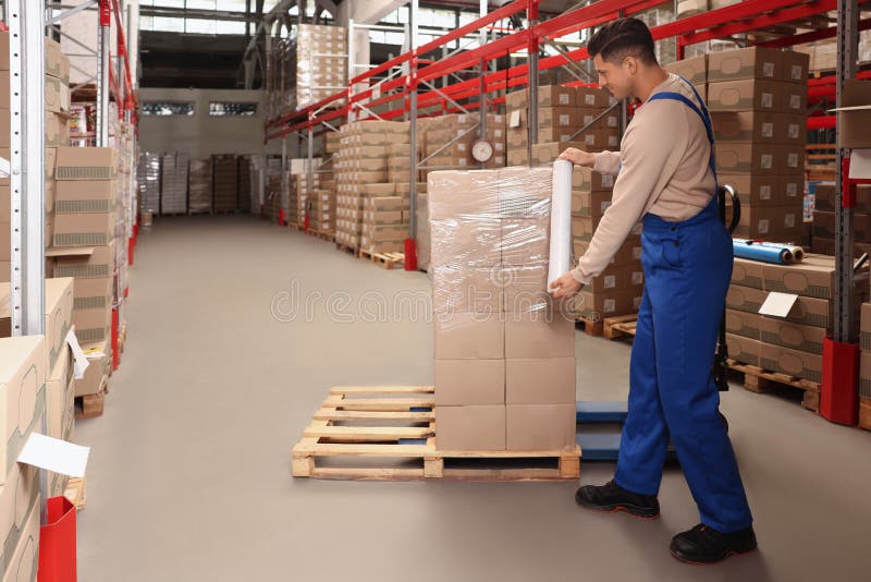 Worker Wrapping Boxes in Stretch Film at Warehouse Stock Photo - Image ...