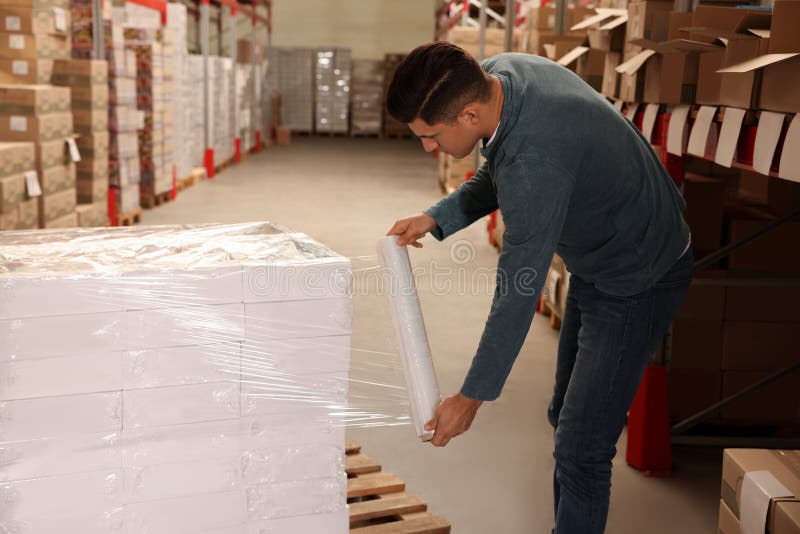 Worker Wrapping Boxes in Stretch Film at Warehouse Stock Photo - Image ...