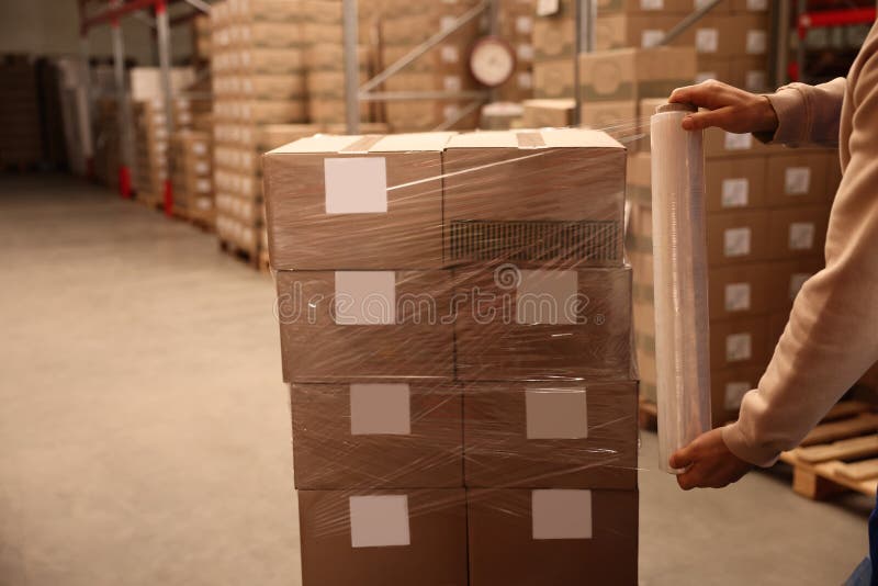Worker Wrapping Boxes in Stretch Film at Warehouse, Closeup Stock Photo ...