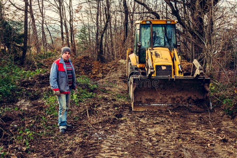 Worker and Yellow Old Excavator in the Forest Dig a Pit for Water ...