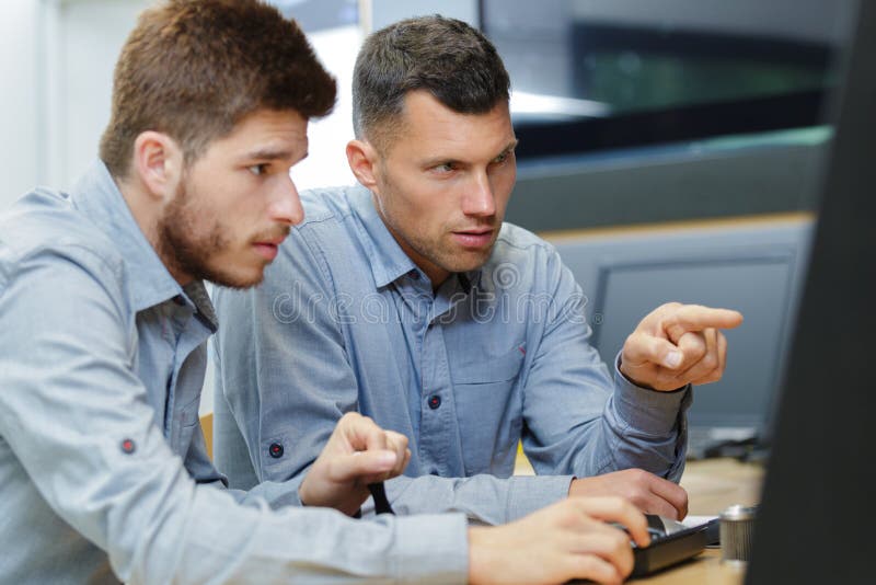Worker and Young Helper Pointing at Laptop Stock Image - Image of plans ...