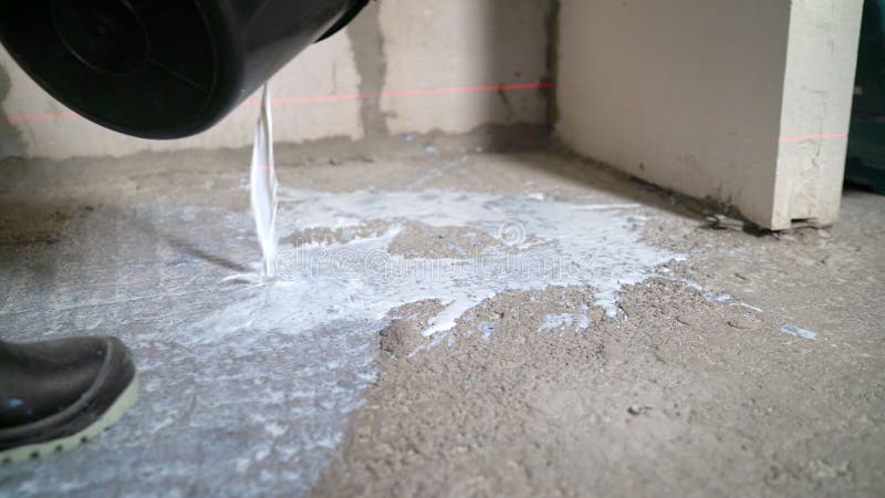 Workers Flood the Floor. Liquid Flooring. Leveling the Floor with a ...