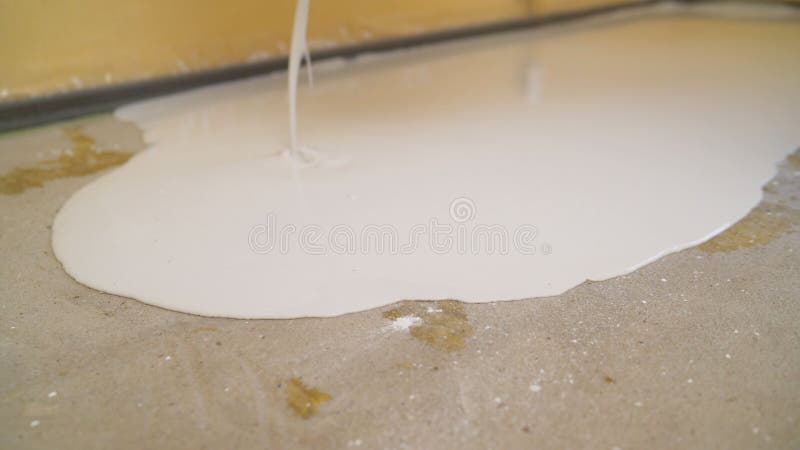 Workers Flood the Floor. Liquid Flooring. Leveling the Floor with a ...