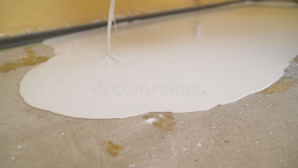 Workers Flood the Floor. Liquid Flooring. Leveling the Floor with a ...