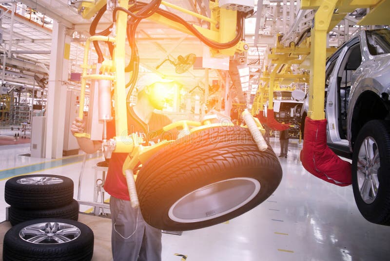 Workers Assembling Vehicles in a Modern Factory during a Busy ...