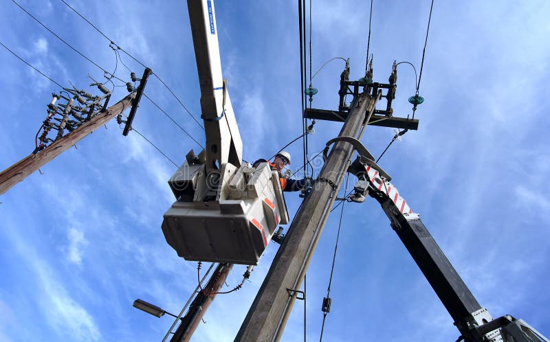 Workers in a Bucket or Cherry Picker Work on Powerlines. Stock Photo ...