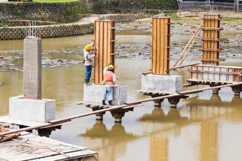 Workers Building Bridge Foundation Across Lake Stock Photo - Image of ...